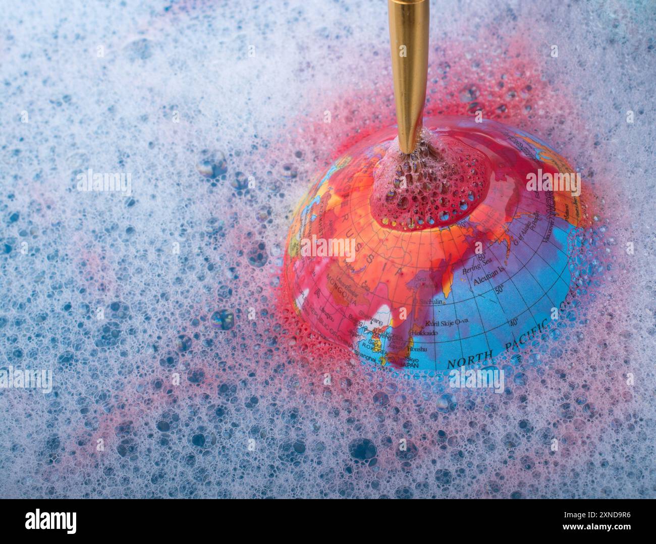 Paint dissolving through painting brush on the top of globe Stock Photo ...