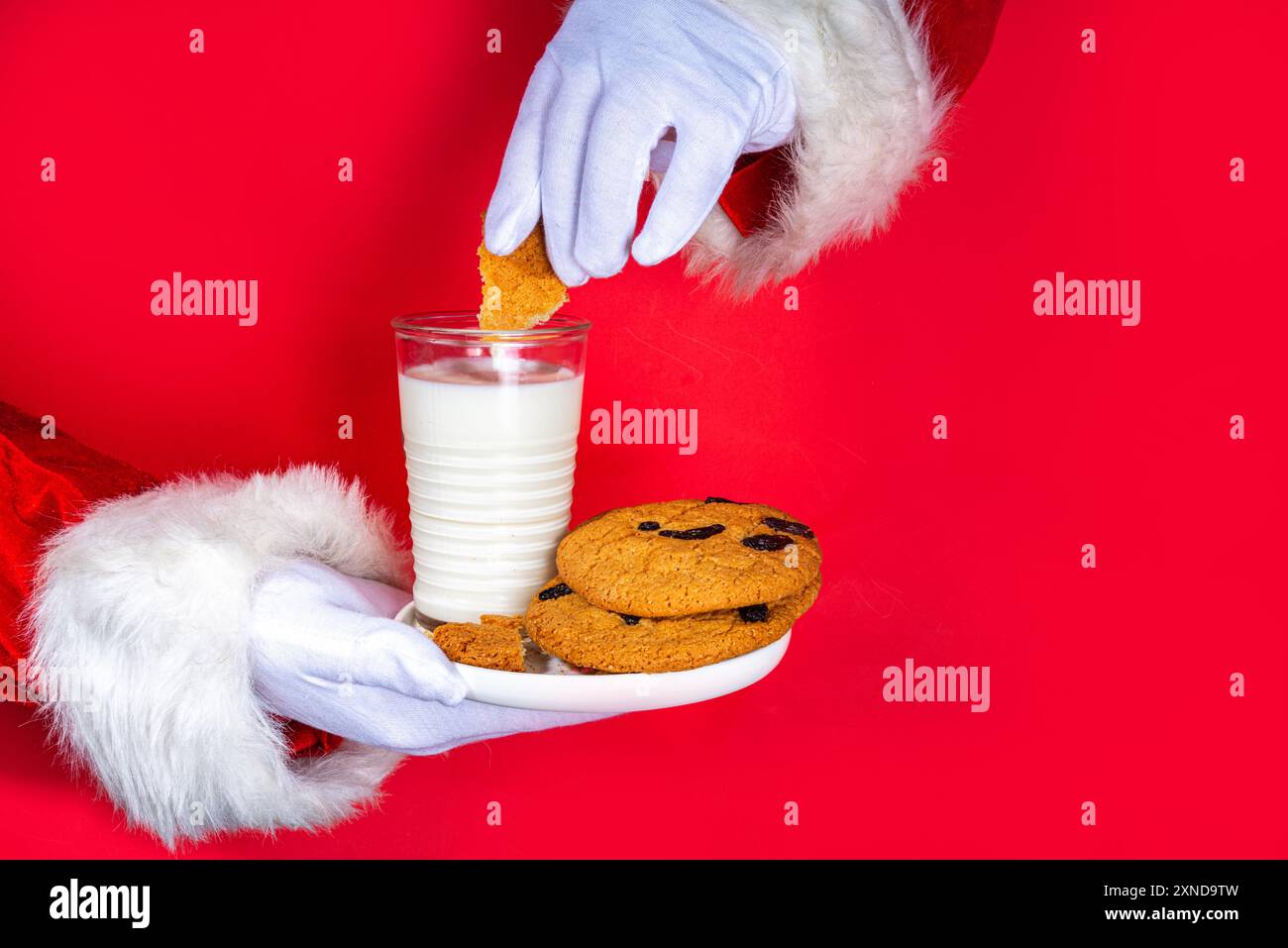 Hand of Santa Claus with traditional Christmas cookie snack with milk ...