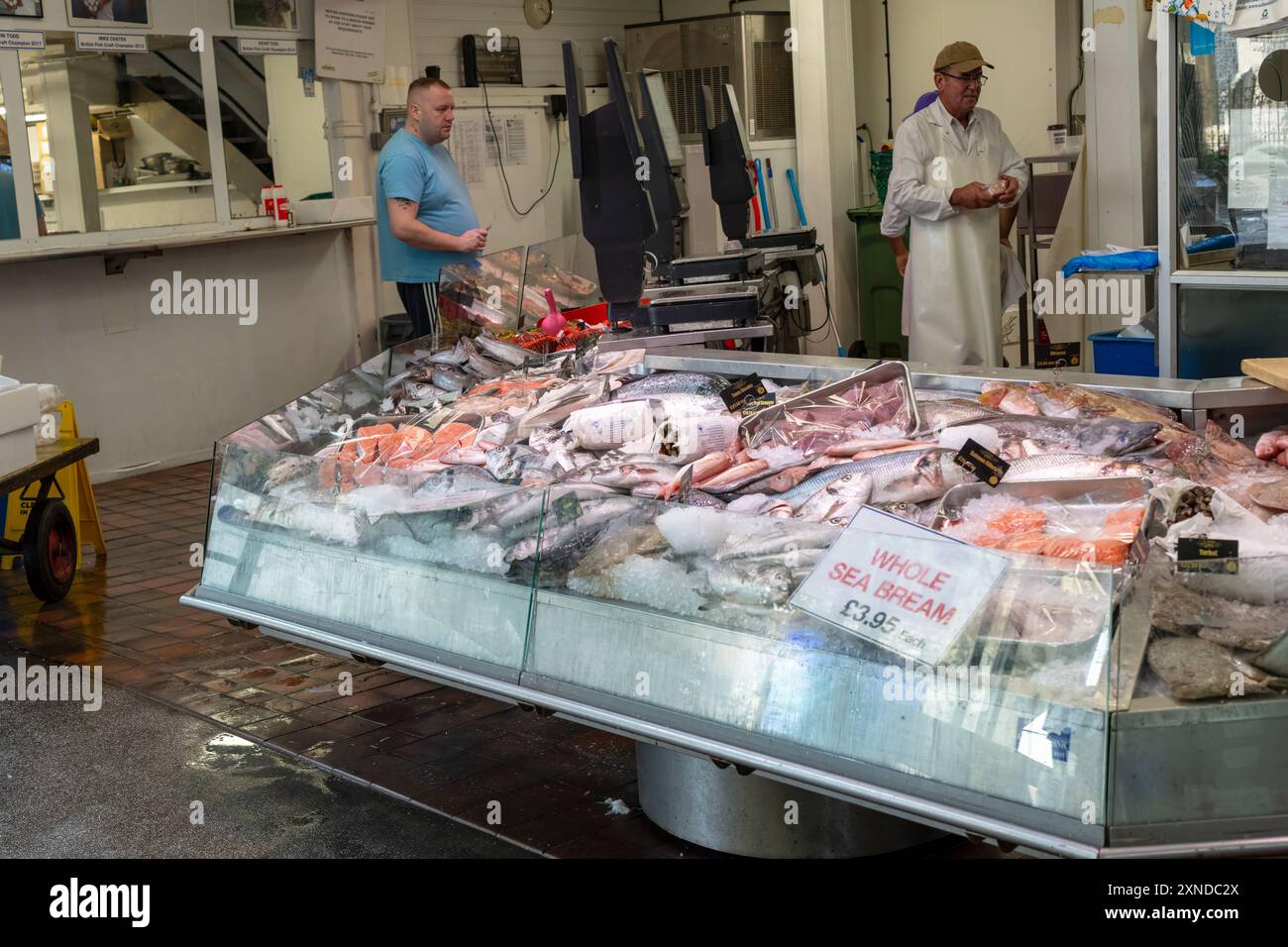 A customer being served at the fish stall. Various fish packed in ice ...