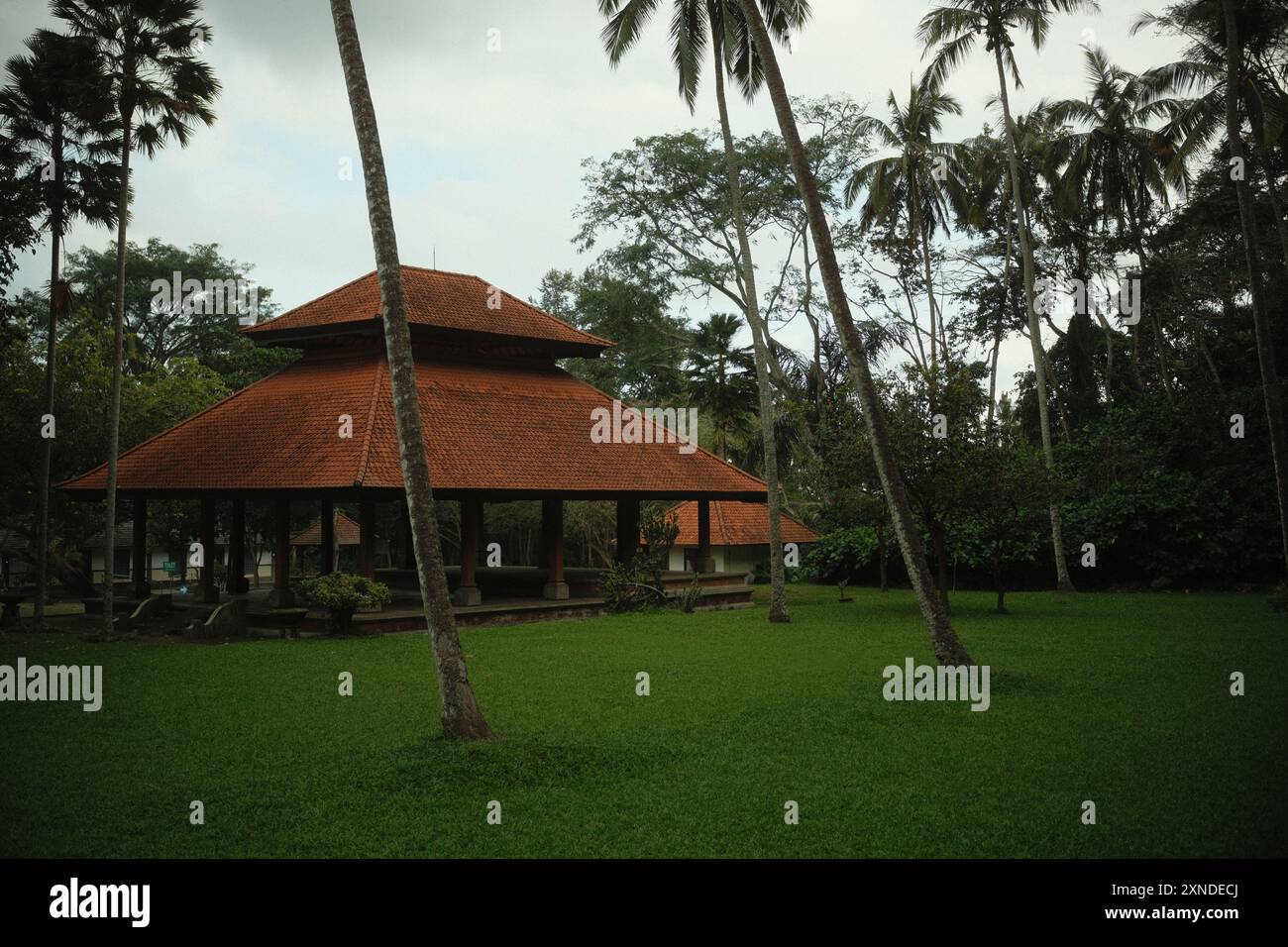 A multifunctional open building with a clay roof, situated on a grassy ...