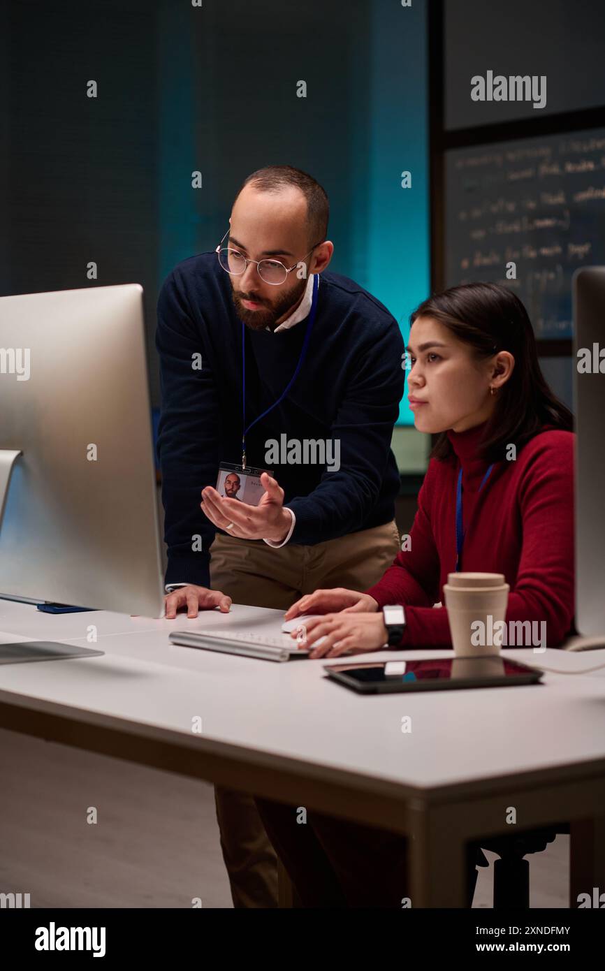 Vertical portrait of cybersecurity team of two people using computer ...