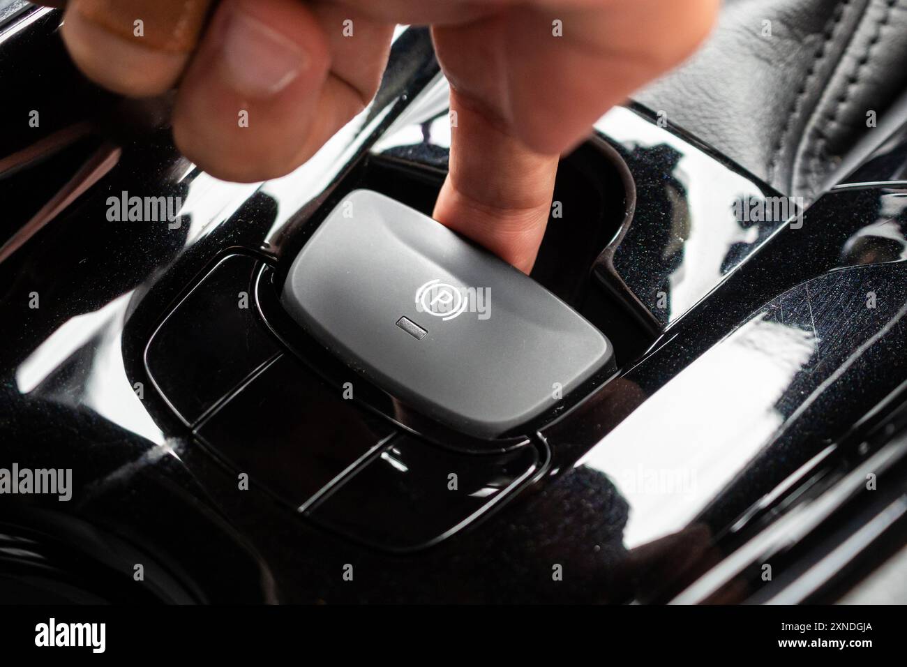 Hand push on electronic handbrake button in luxury modern car Stock ...