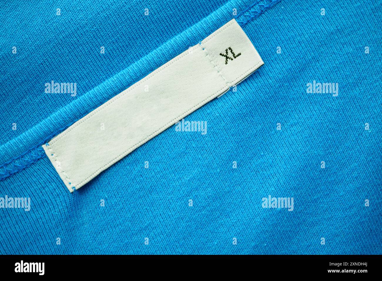 Blank white clothes tag label with XL size on new blue shirt Stock ...