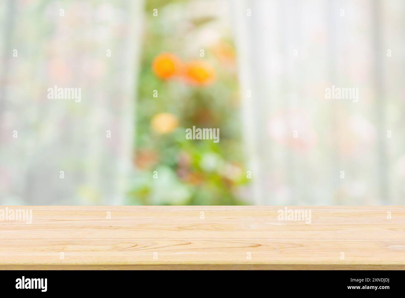 Empty wood table top with blur white curtain window and green garden ...