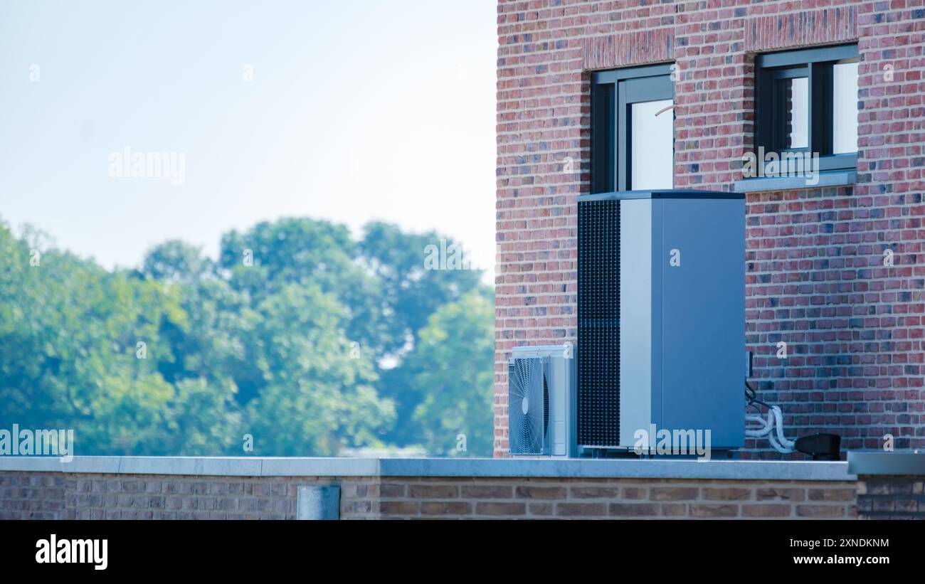 A modern air source heat pump rests on the rooftop of a contemporary ...