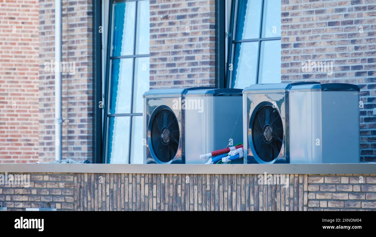 Three sleek air source heat pumps are installed on a stylish brick wall ...
