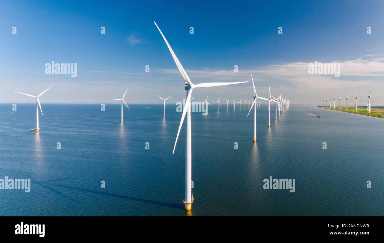 Giant wind turbines harnessing wind power in the tranquil waters of the ...