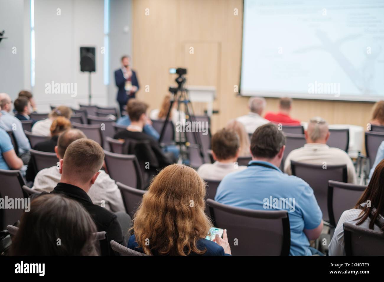 Business conference with speaker addressing an audience in a modern ...