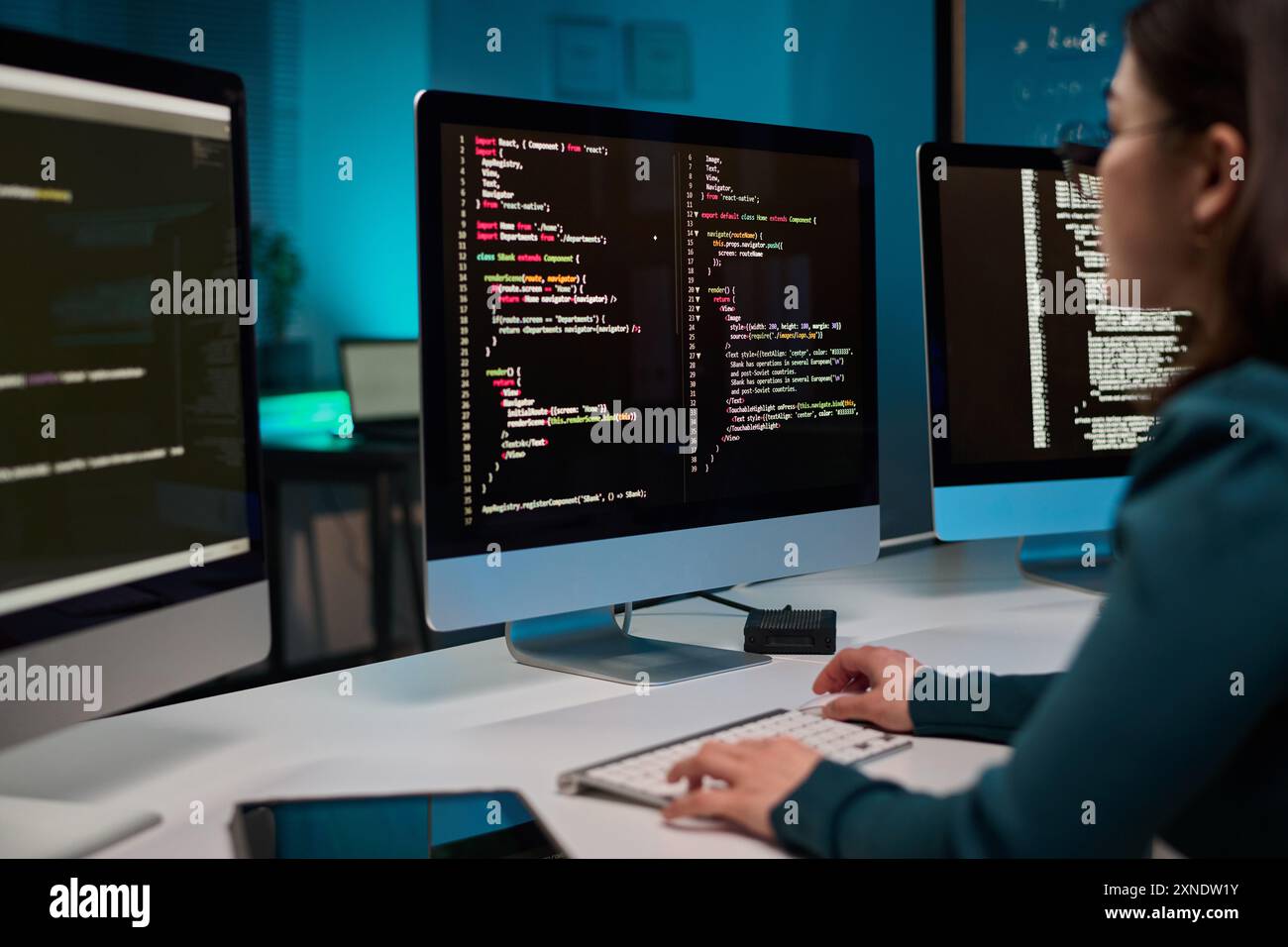 Computer with code lines on screen and unrecognizable young woman ...