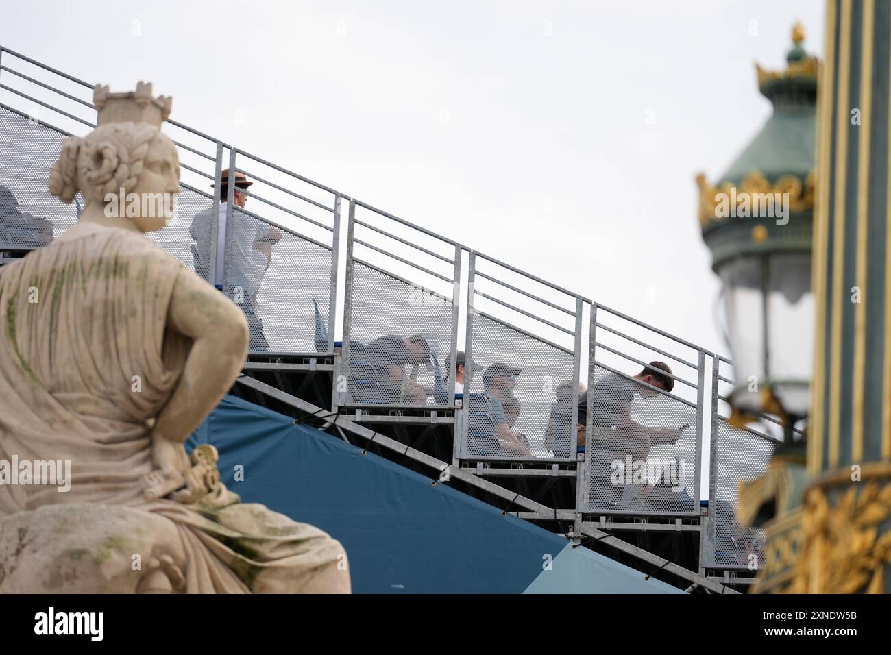 People sit in spectator stands alongside monuments, in Place de la ...