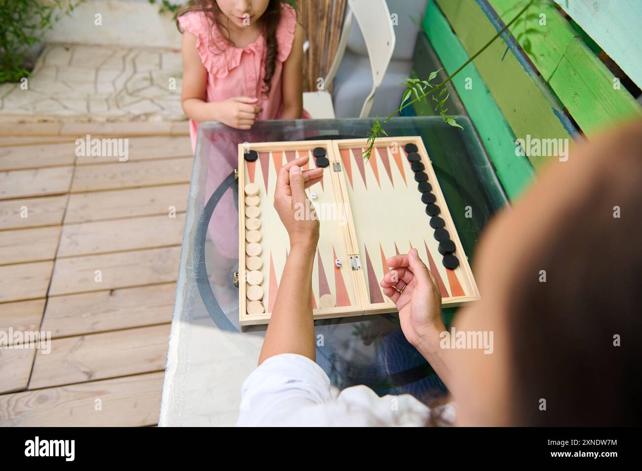 A mother and her daughter engage in a fun game of backgammon at an ...