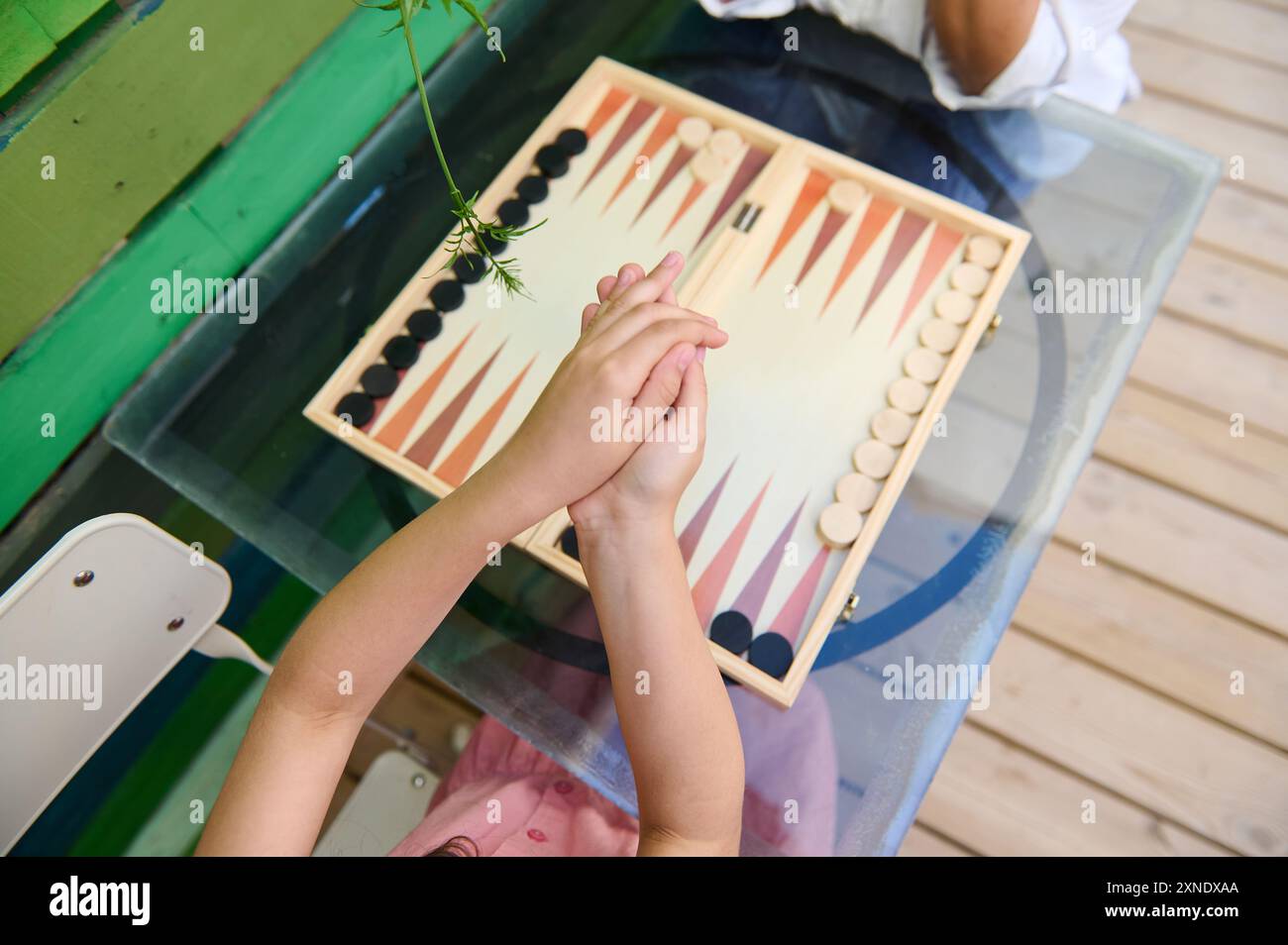 Two children enjoying a game of backgammon outdoors, captured at the ...