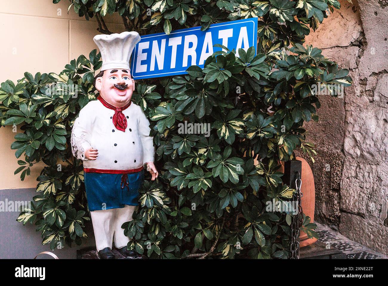 A cheerful chef statue stands beside an ENTRATA sign, welcoming guests ...