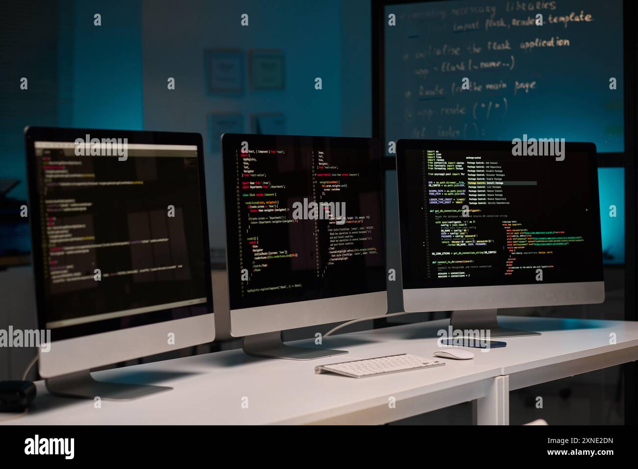 Background Image Of Three Computer Monitors With Code Lines On Table In It Development Office