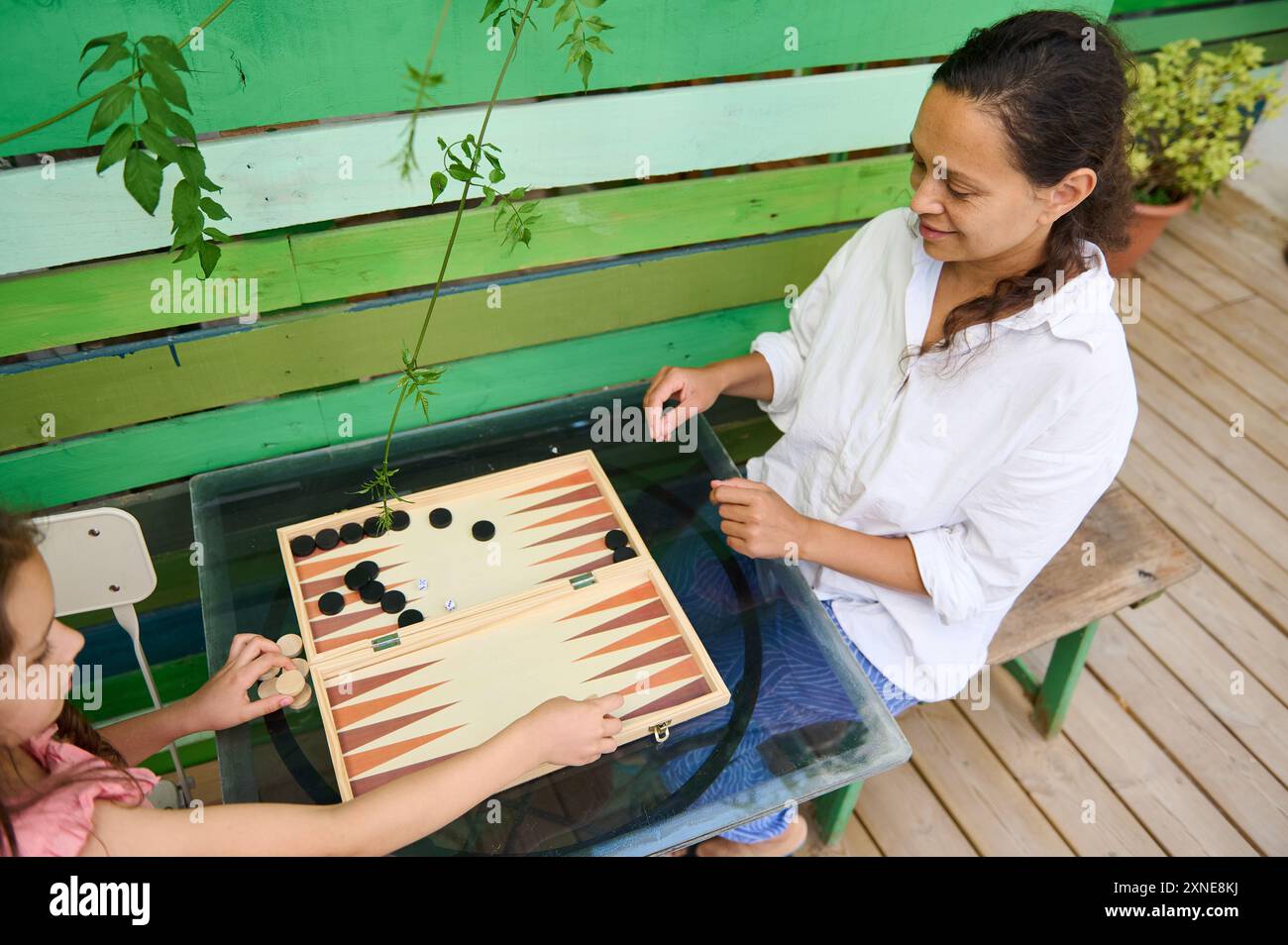 A mother and daughter enjoying a game of backgammon on a colorful ...