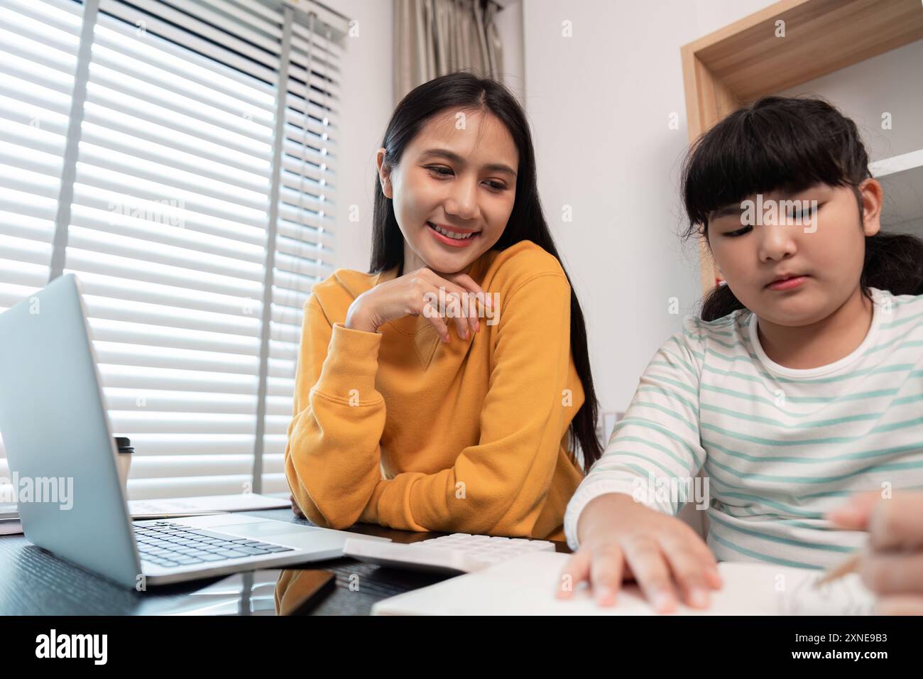 Mother and Child Working from Home Together on a Laptop and Homework in ...