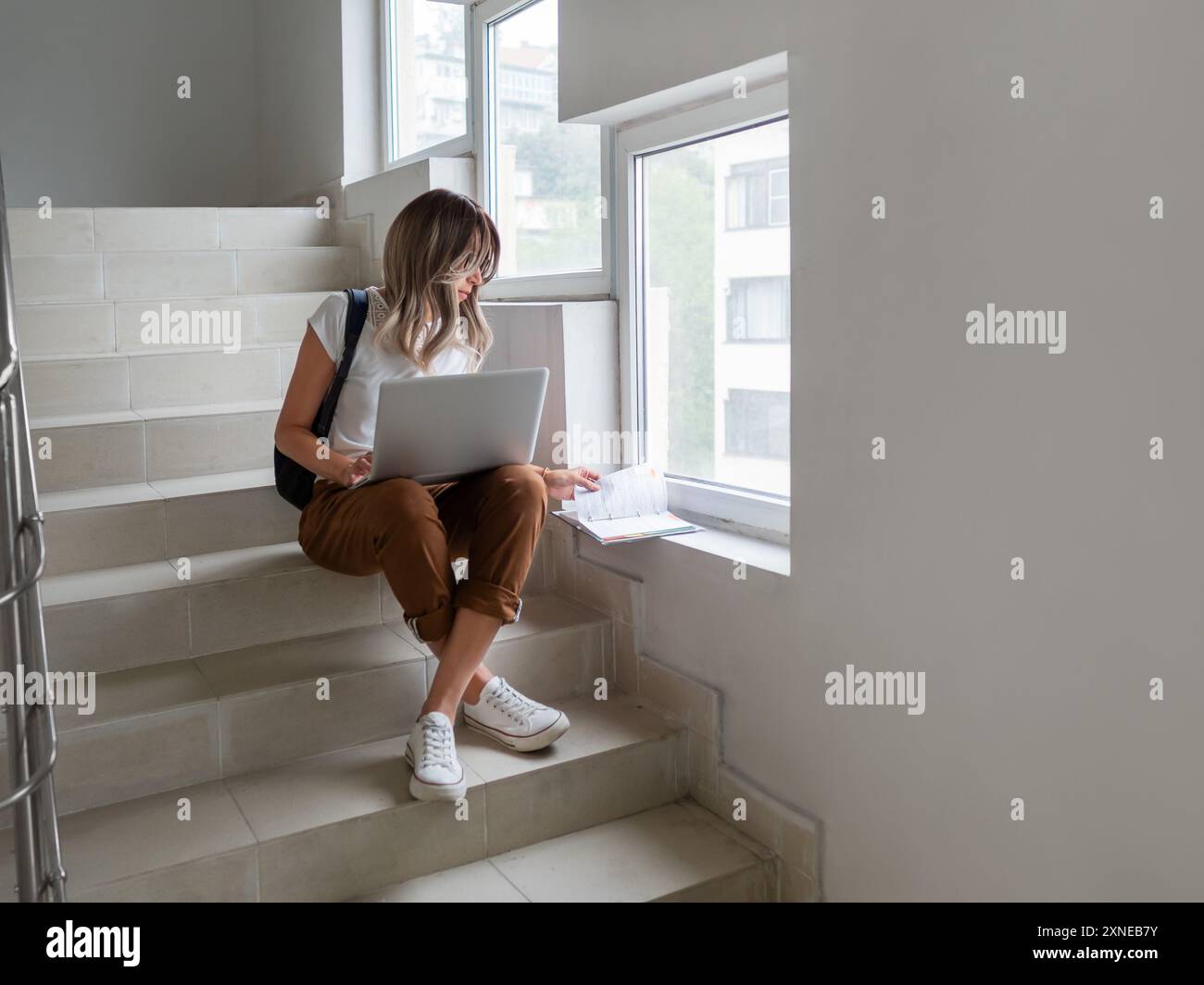 Thoughtful woman looks in notepad with handwriten notes. Student is ...