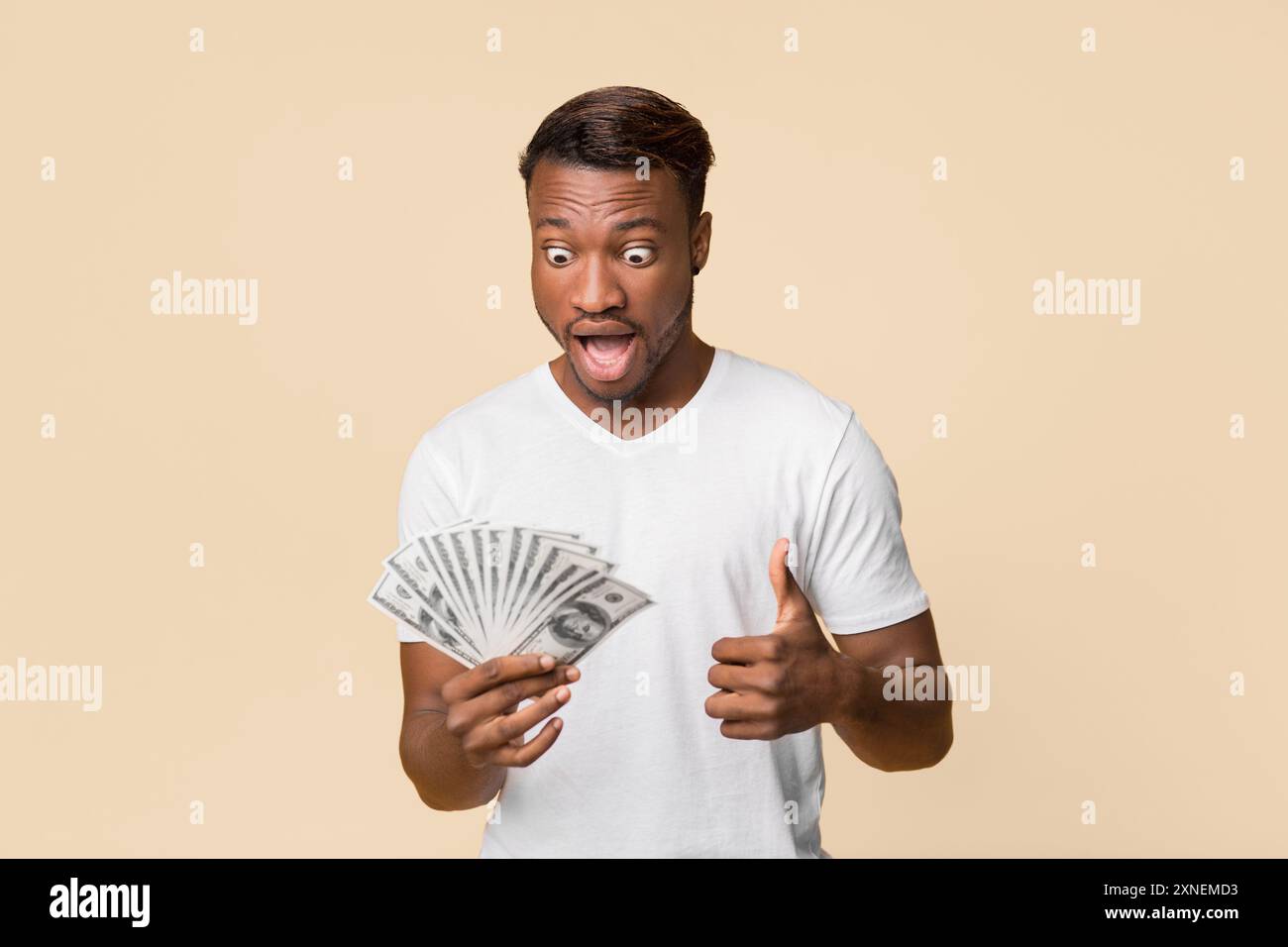 Shocked Man Holding Bunch Of Money Gesturing Thumbs-Up, Yellow ...