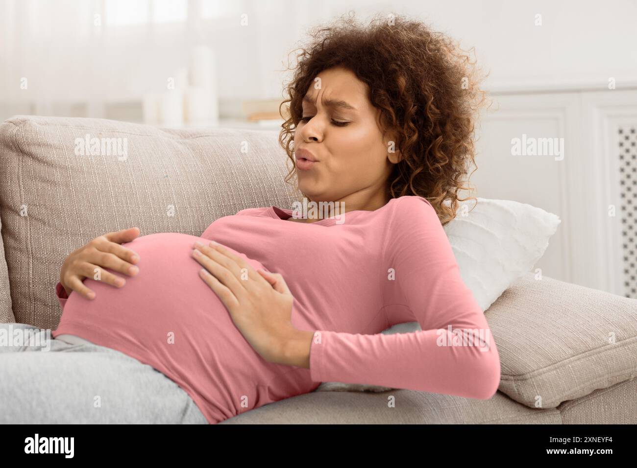 Expectant woman having contractions and doing breathing exercises Stock ...