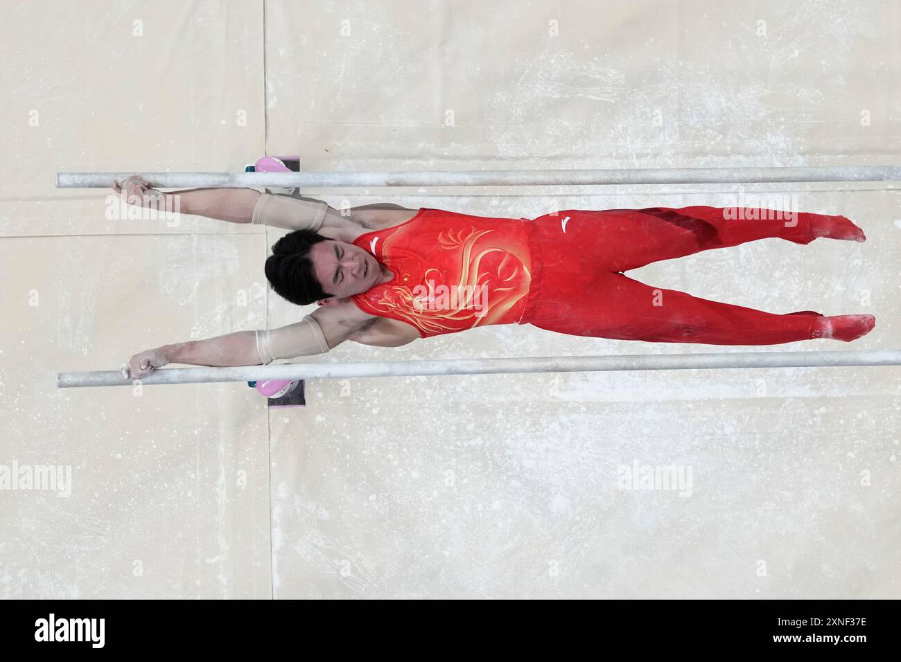 Zhang Boheng, of China, performs on the parallel bars during the men's ...