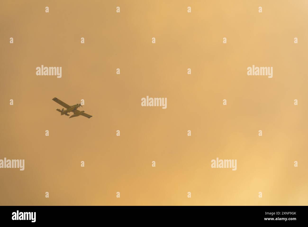 Firefighting plane flying into a large smoke cloud caused by a forest ...