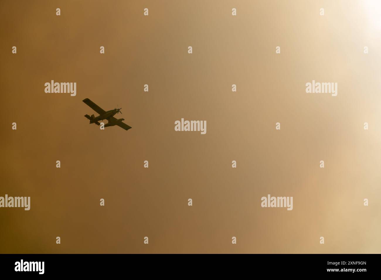 Firefighting plane flying into a large smoke cloud caused by a forest ...