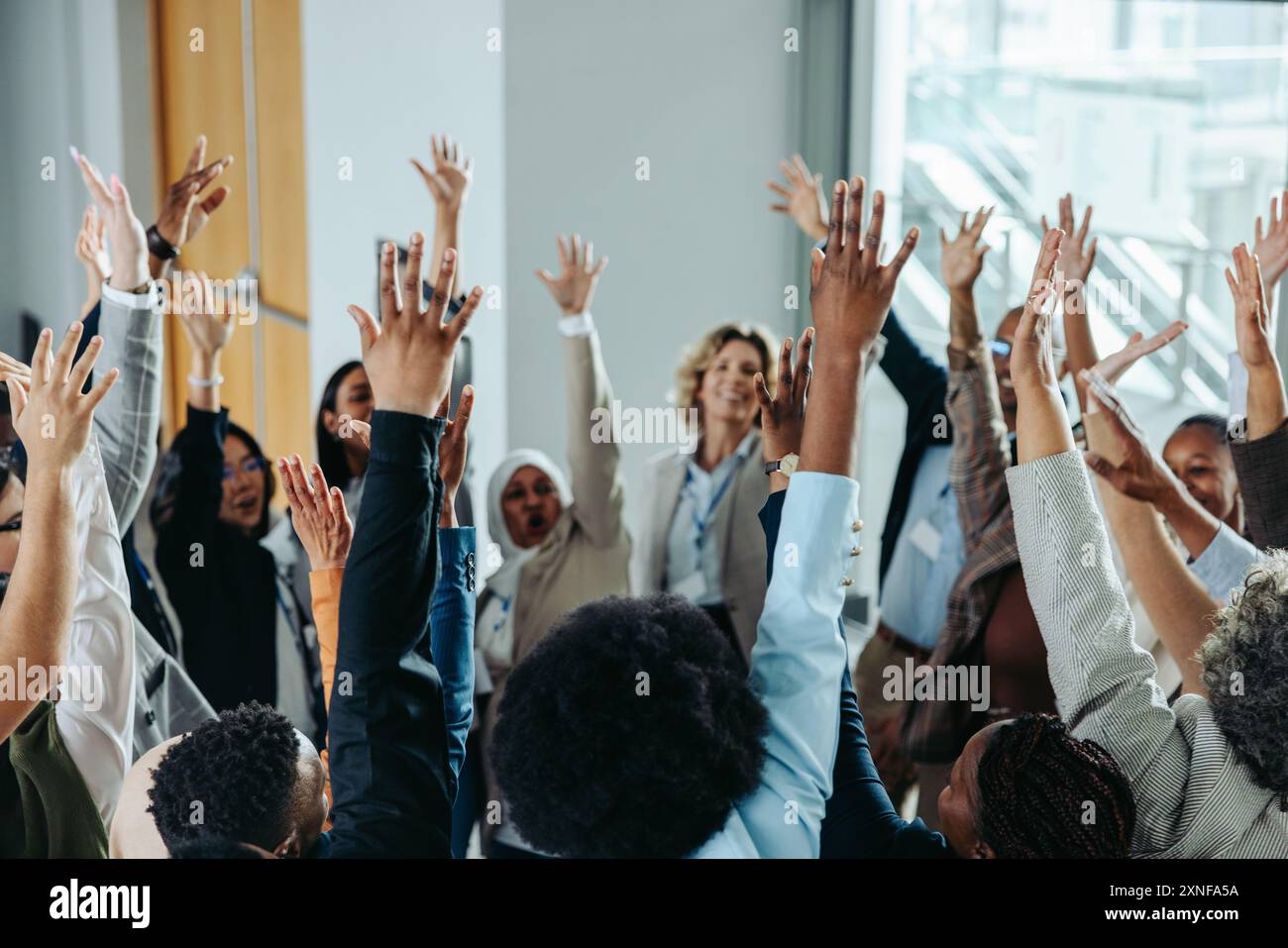 Diverse business group raising hands in unison during a conference ...