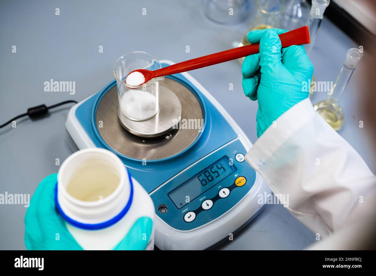 A woman chemist measures powder samples with laboratory balances Stock ...