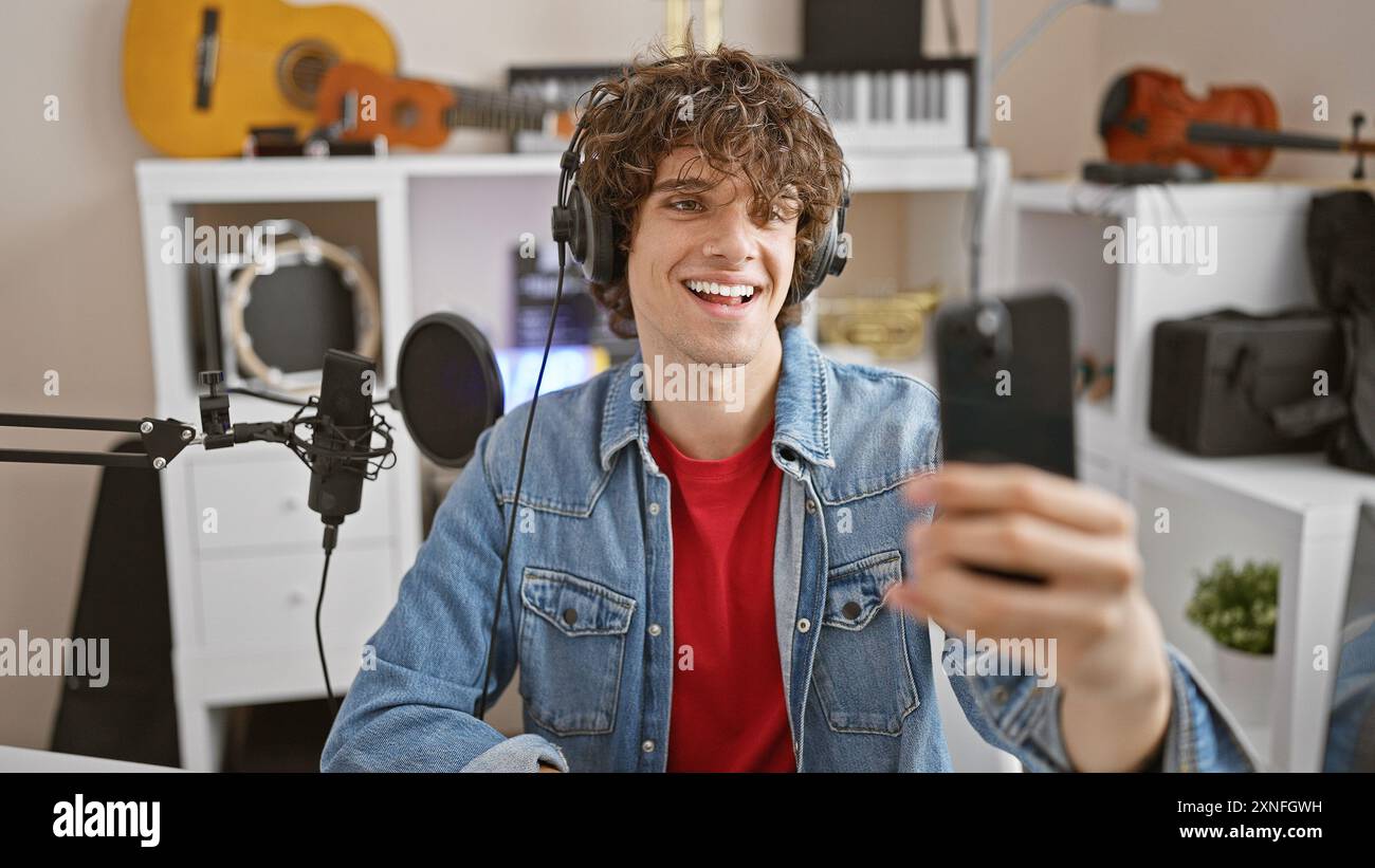 A handsome man with curly hair taking a selfie in a music studio ...