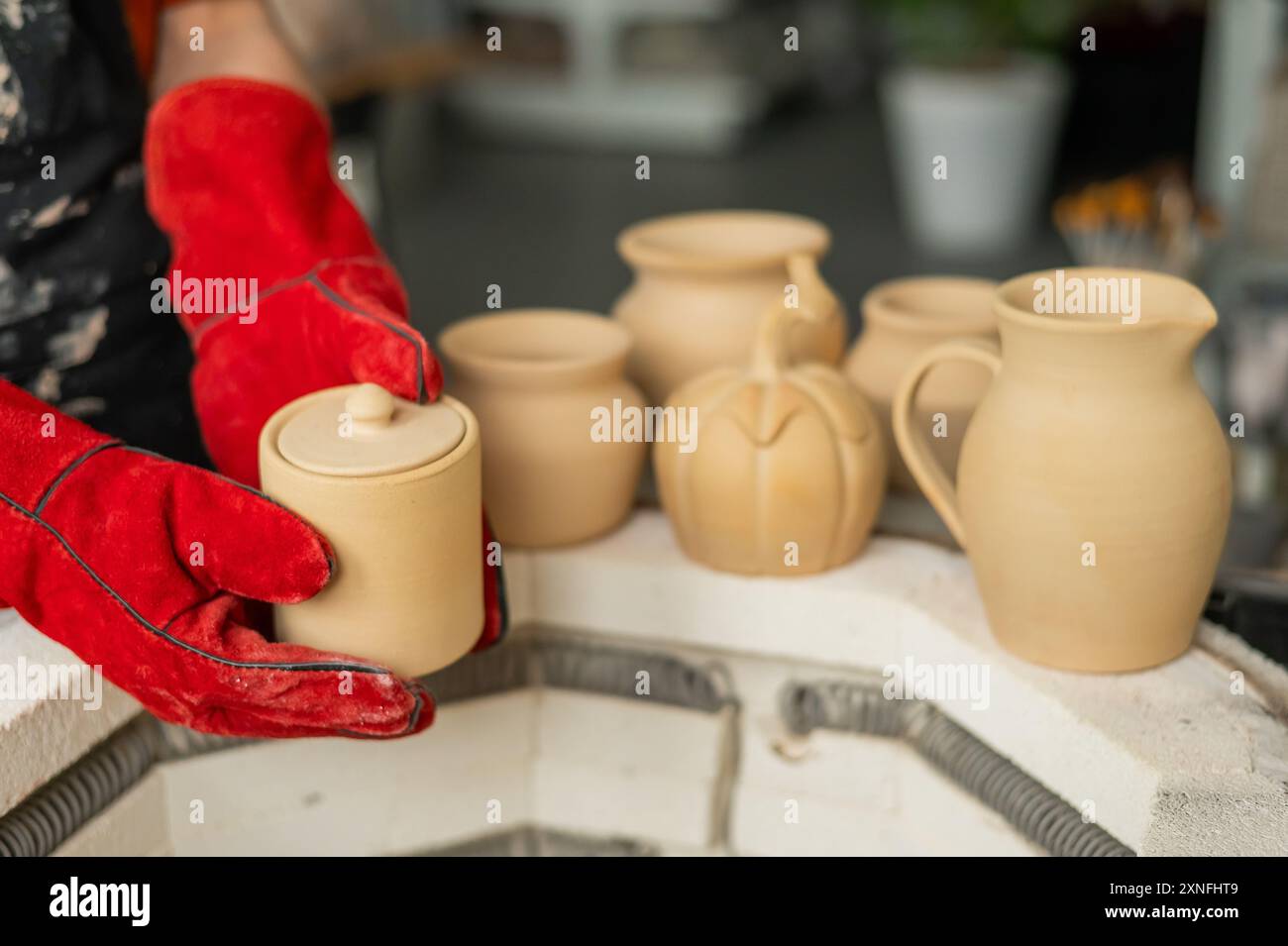 Close-up of a man's hands loading ceramics into a special kiln Stock ...