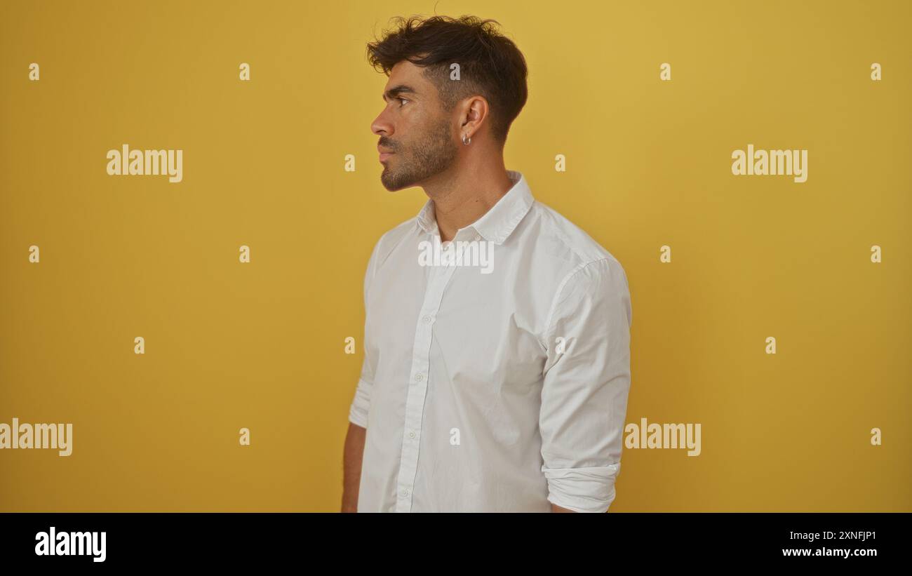 Handsome young hispanic man in a white shirt standing against an ...