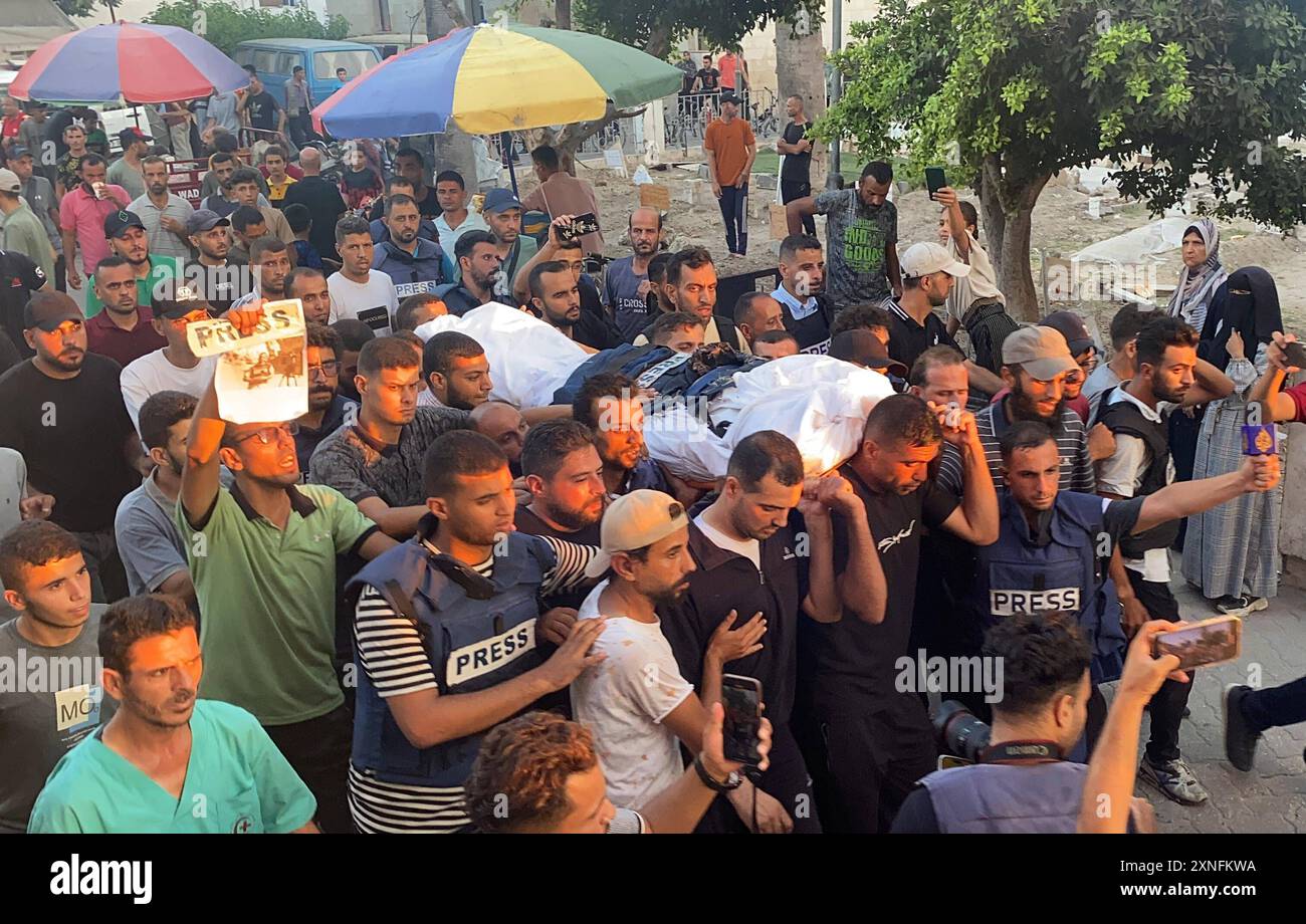 Mourners and colleagues surround the bodyies of Al-Jazeera Arabic ...