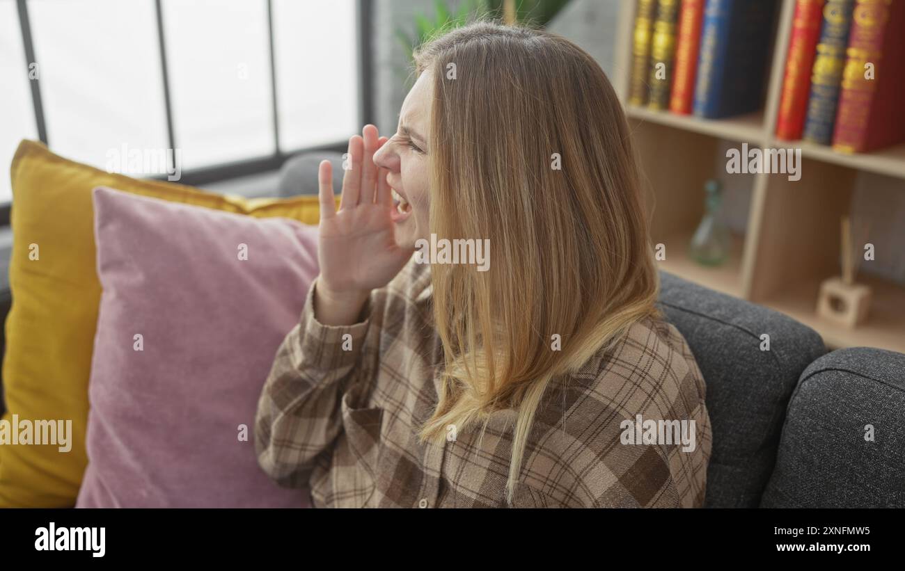 A young blonde woman shouts indoors, expressing emotion, in a cozy ...