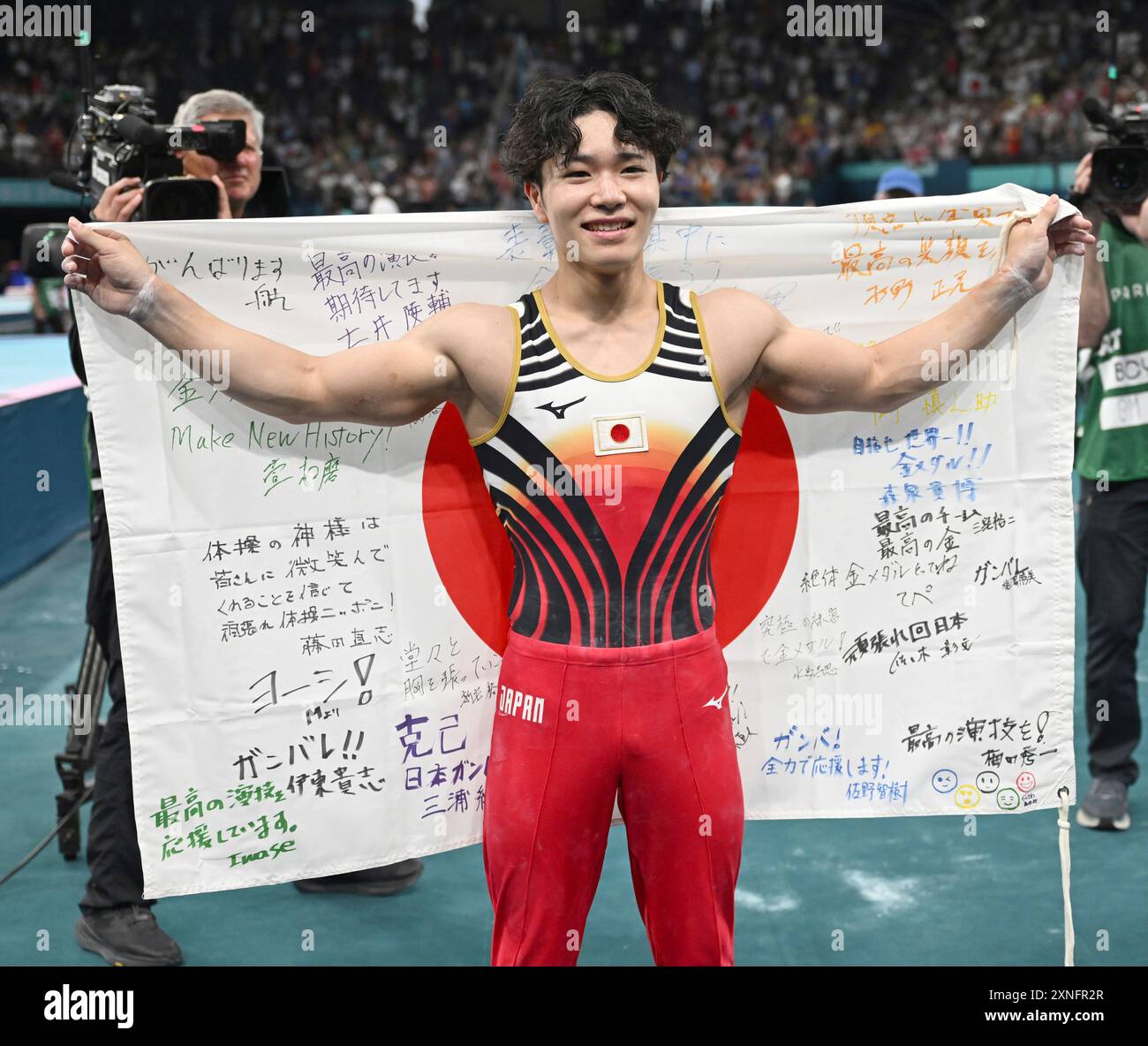 Japan's Shinnosuke Oka holds the national flag after winning the Men's ...