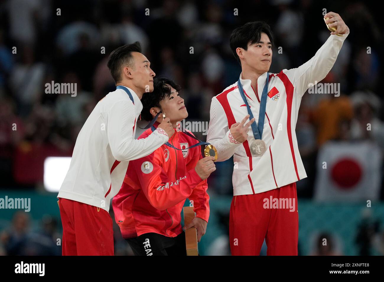 Shinnosuke Oka, center, of Japan, poses with his gold medal alongside silver medalist Zhang ...