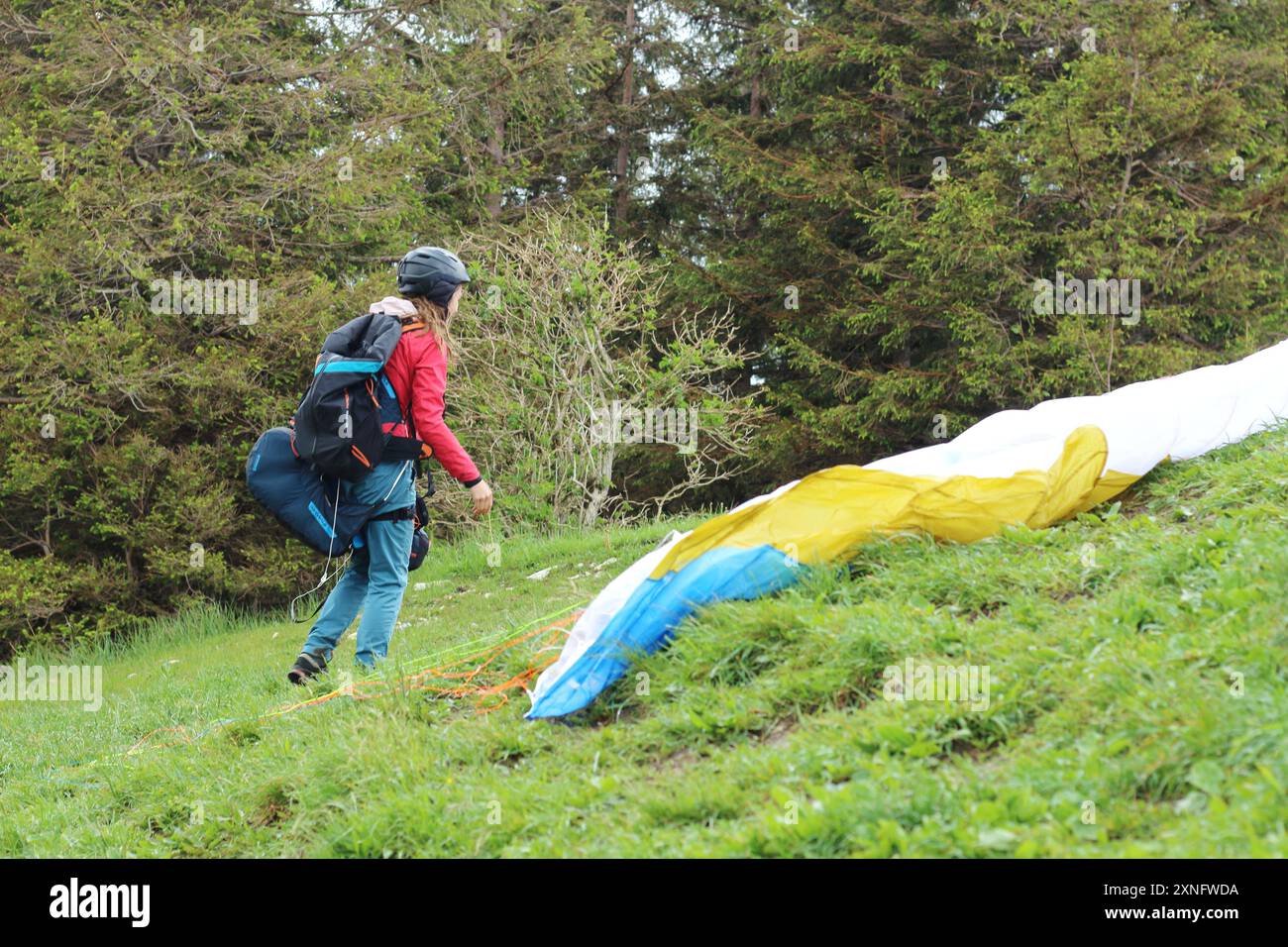 A female paraglider completes her final preparations before taking off ...