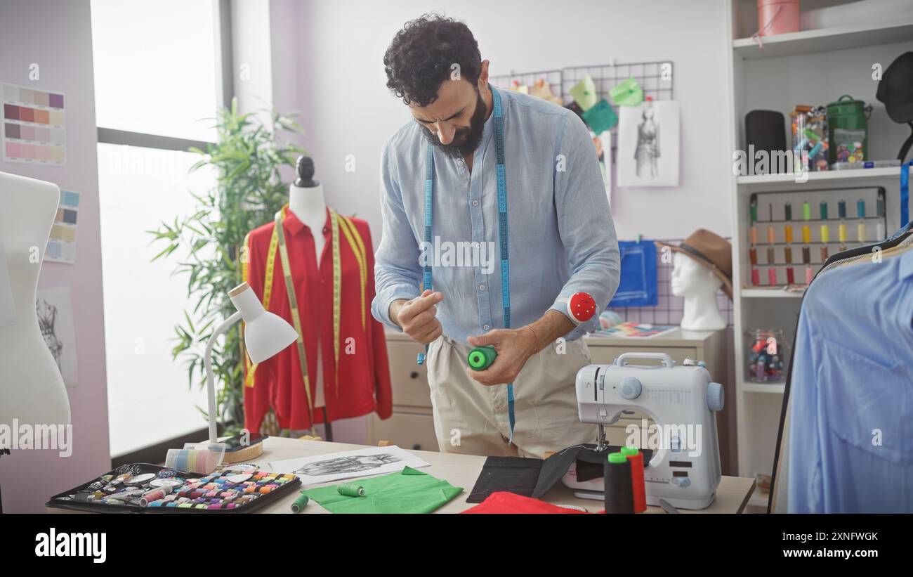 A bearded man in a tailor shop attentively selecting threads with ...