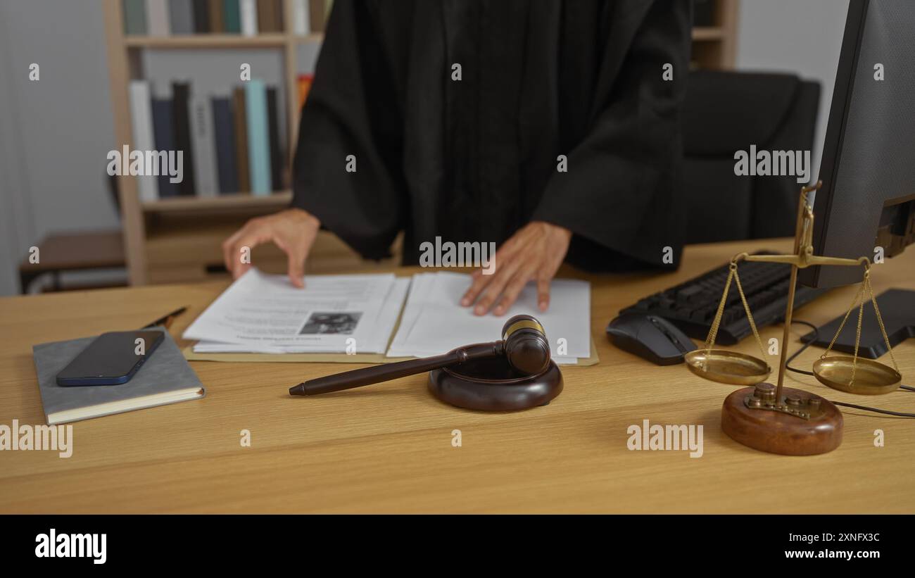 Judge in office with scales of justice and gavel, examining documents ...