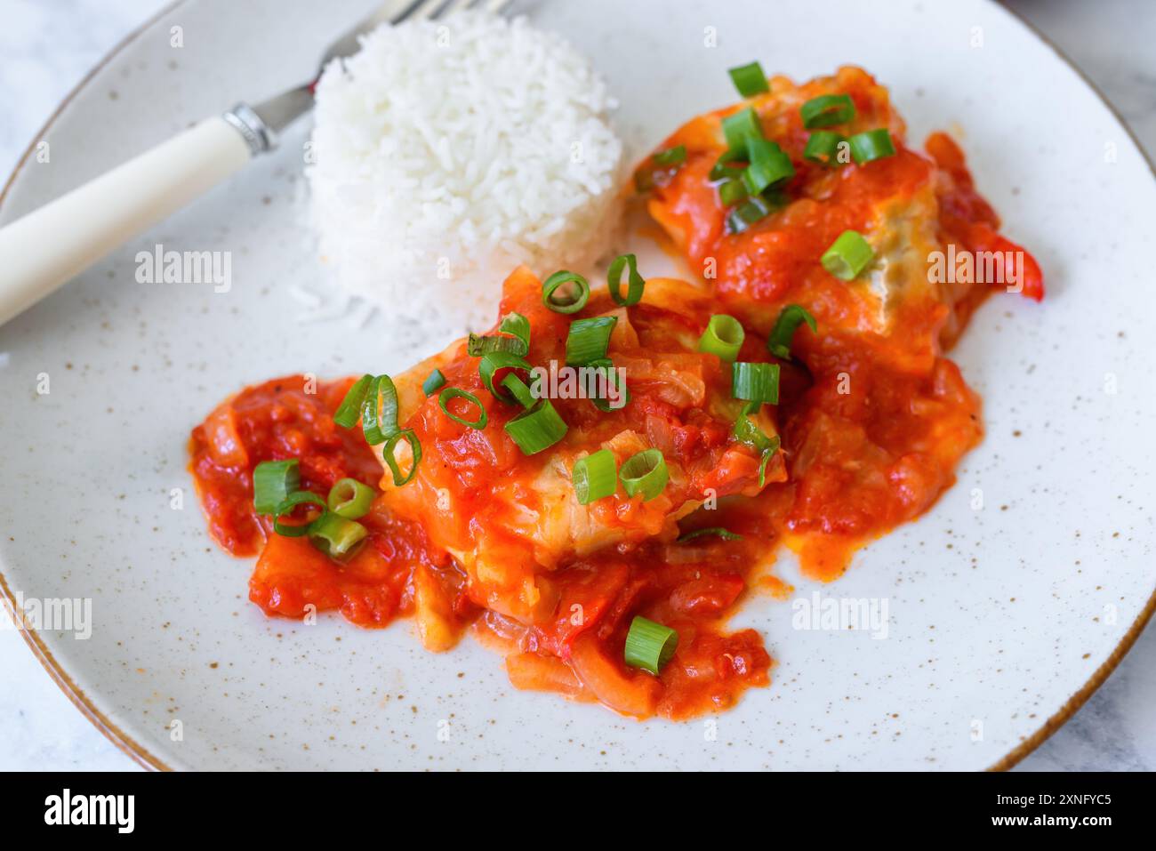 Baked cod fish in tomato and pepper sauce Stock Photo - Alamy