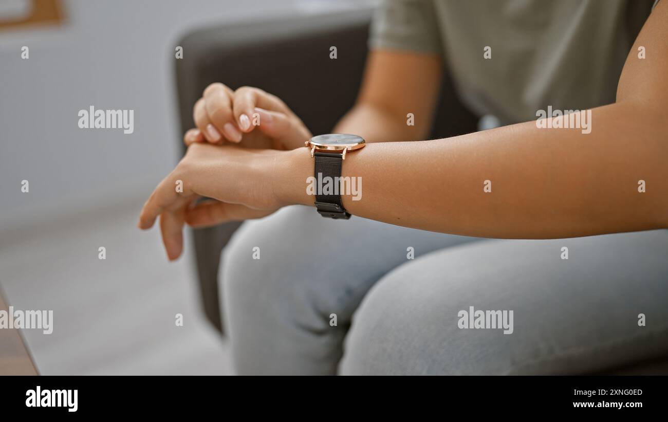 A woman checks the time on her wristwatch in a contemporary office ...