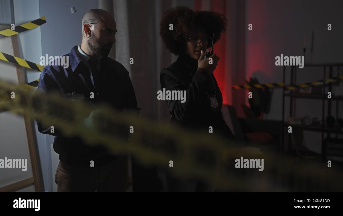 A man and woman investigators with badges examine an indoor crime scene ...