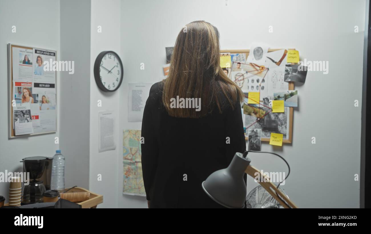 A woman detective analyzes a crime investigation board in an office ...