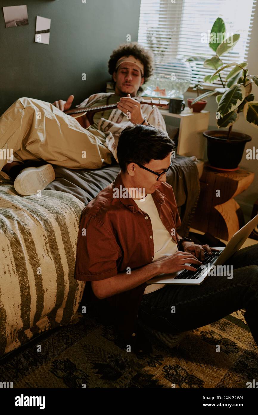 Best friends resting after lectures in dorm room, curly-haired student ...