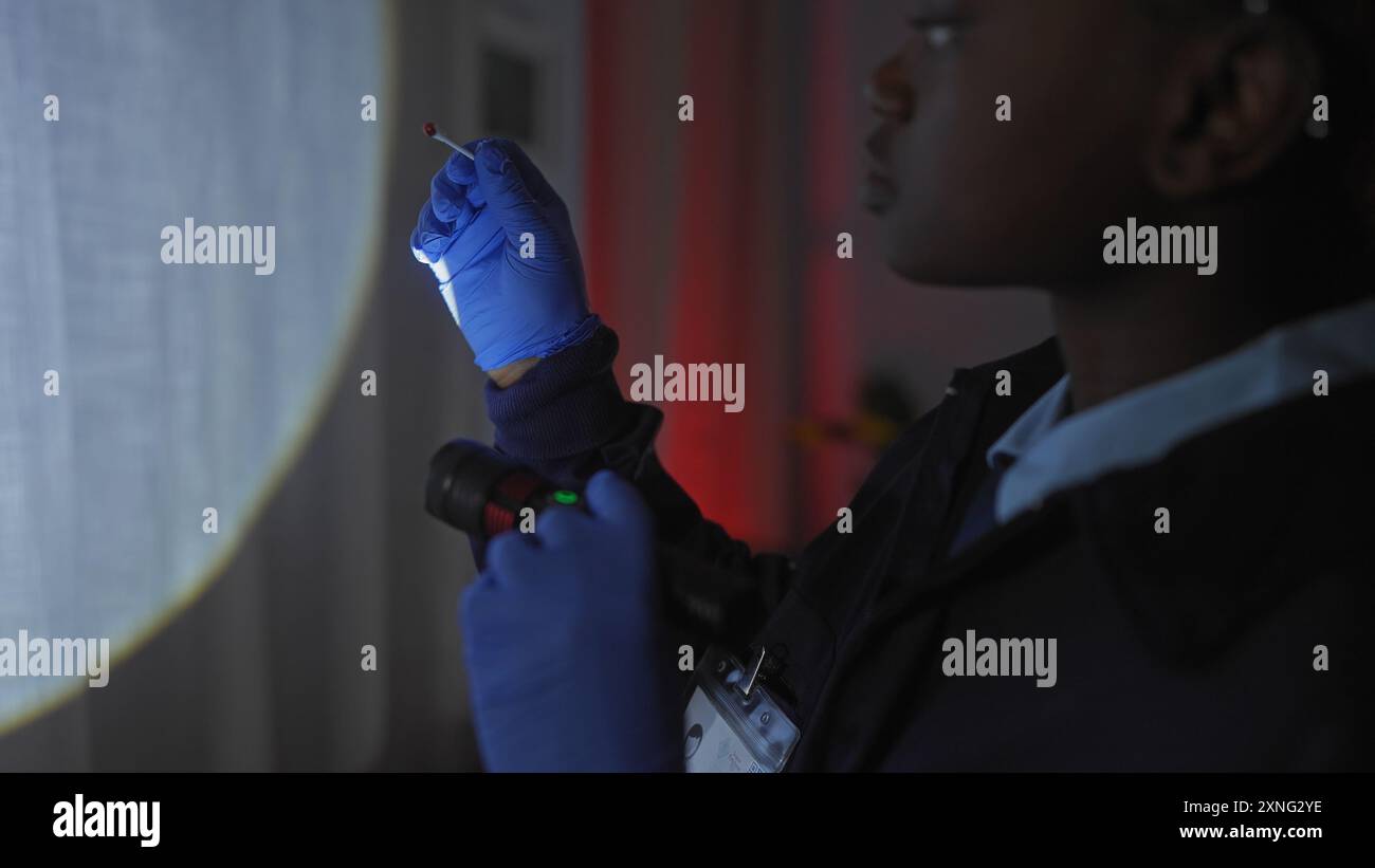 African american woman detective examines evidence at an indoor crime ...