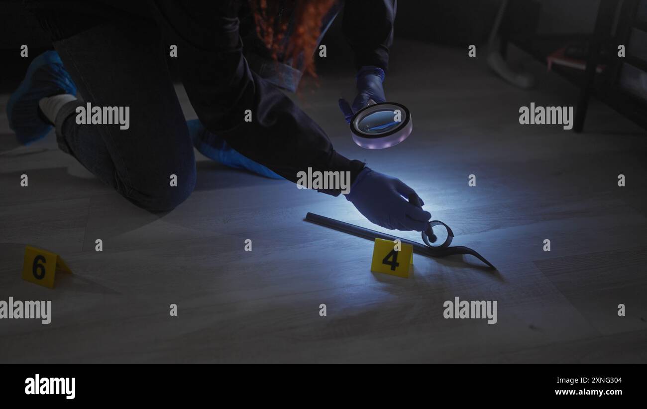 Woman detective analyzing evidence at night in indoor crime scene with ...