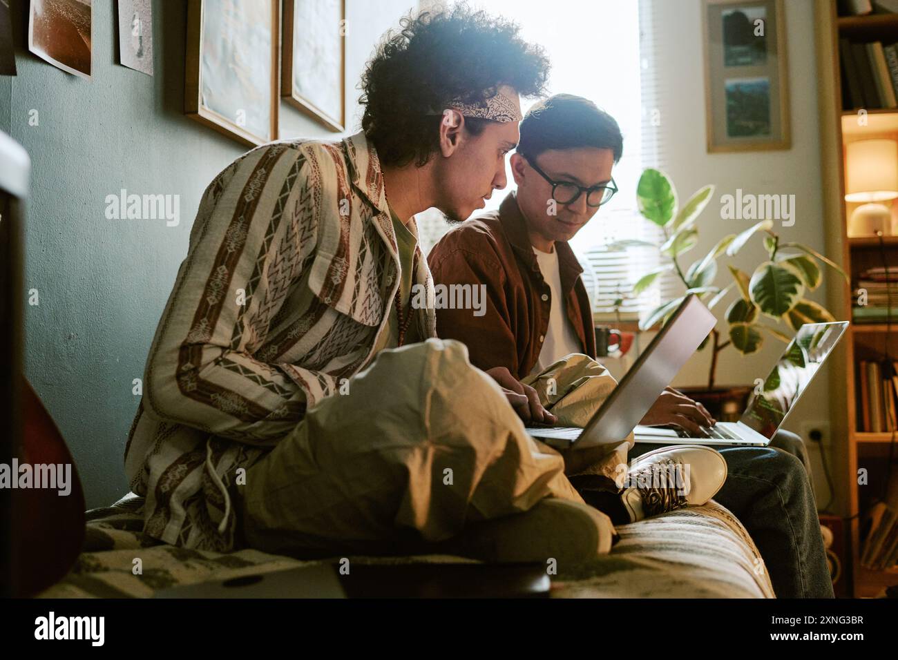 Roomies using laptops to write codes together while they sitting on ... Roomies using laptops to write codes together while they sitting on ...