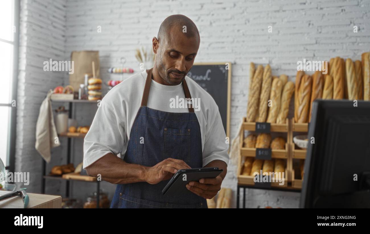 Young man using tablet in bakery shop interior with shelves of bread in ...