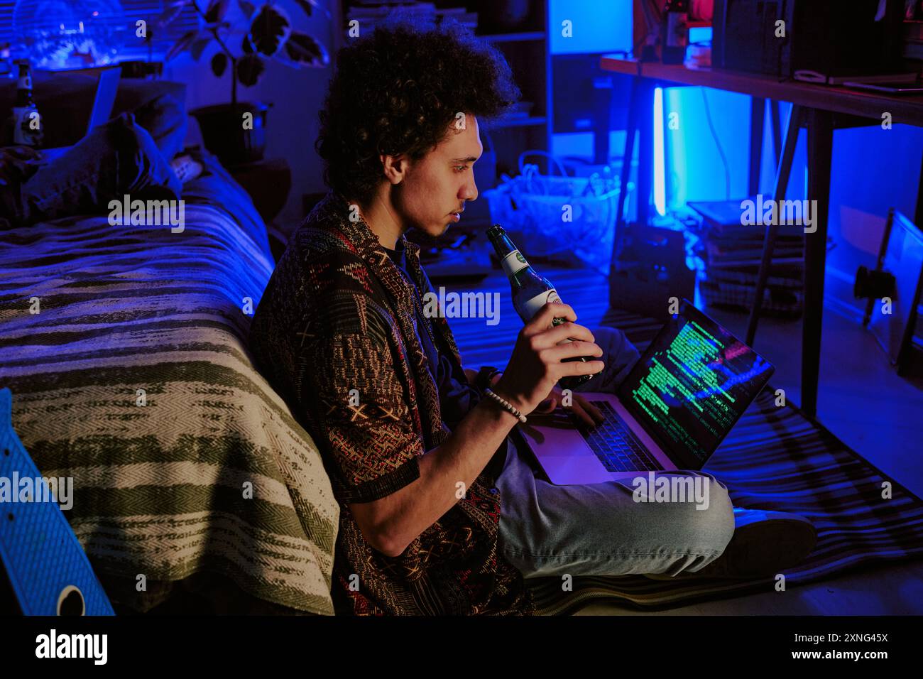 Young Programmer taking beer sip while writing codes for future startup ...