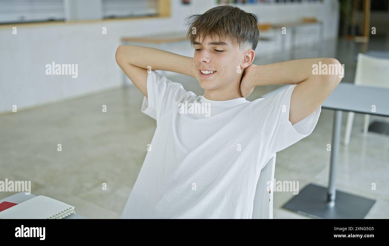 Relaxed teenage boy enjoying a break in a modern school classroom Stock ...
