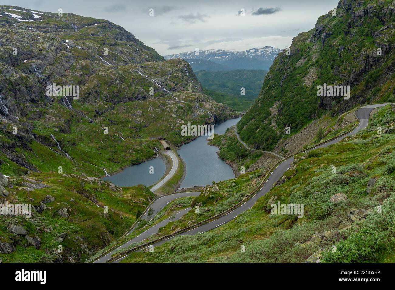 The image features an old winding road that meanders through the rugged ...